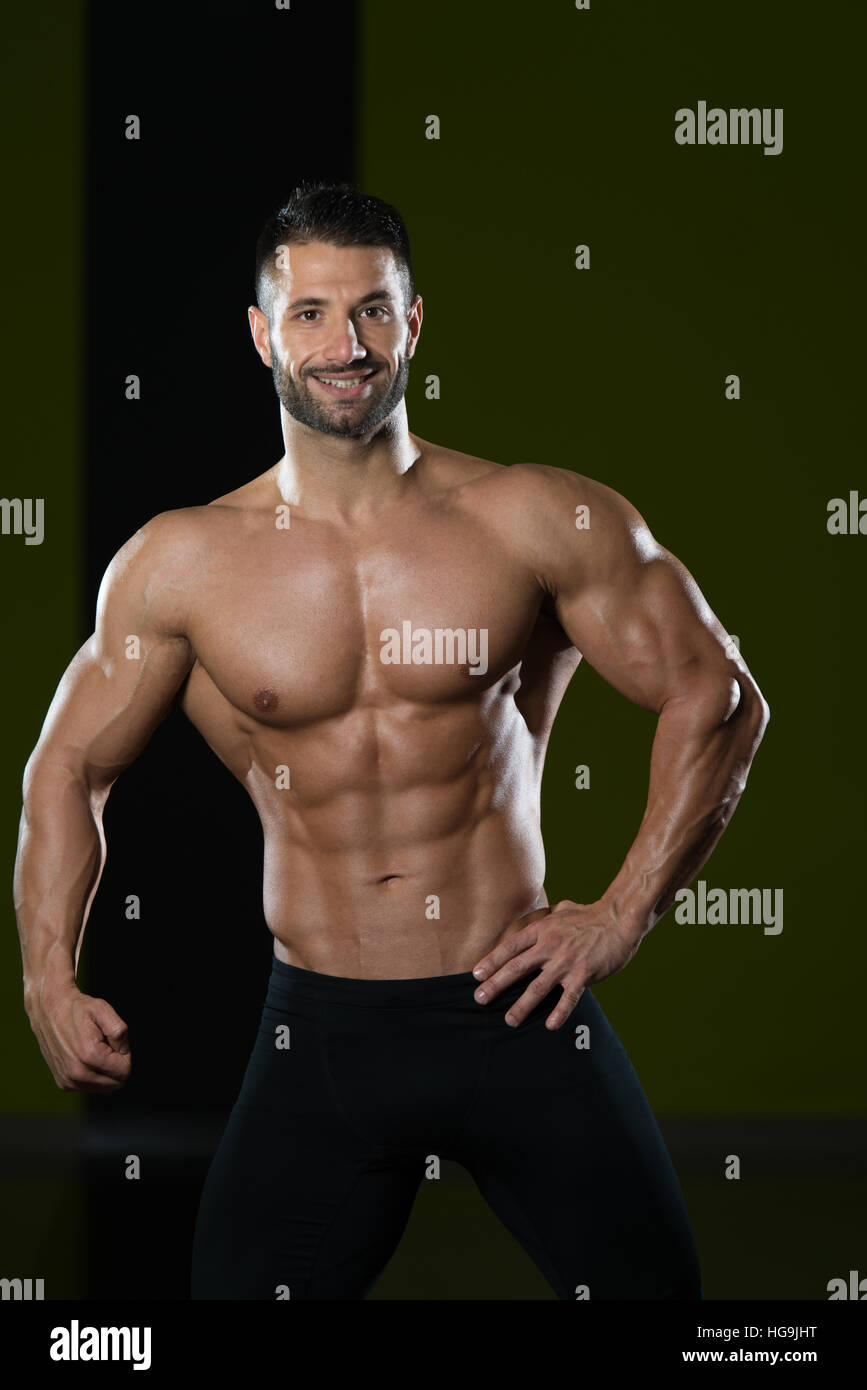 Handsome Man Standing Strong In The Gym And Flexing Muscles - Muscular ...