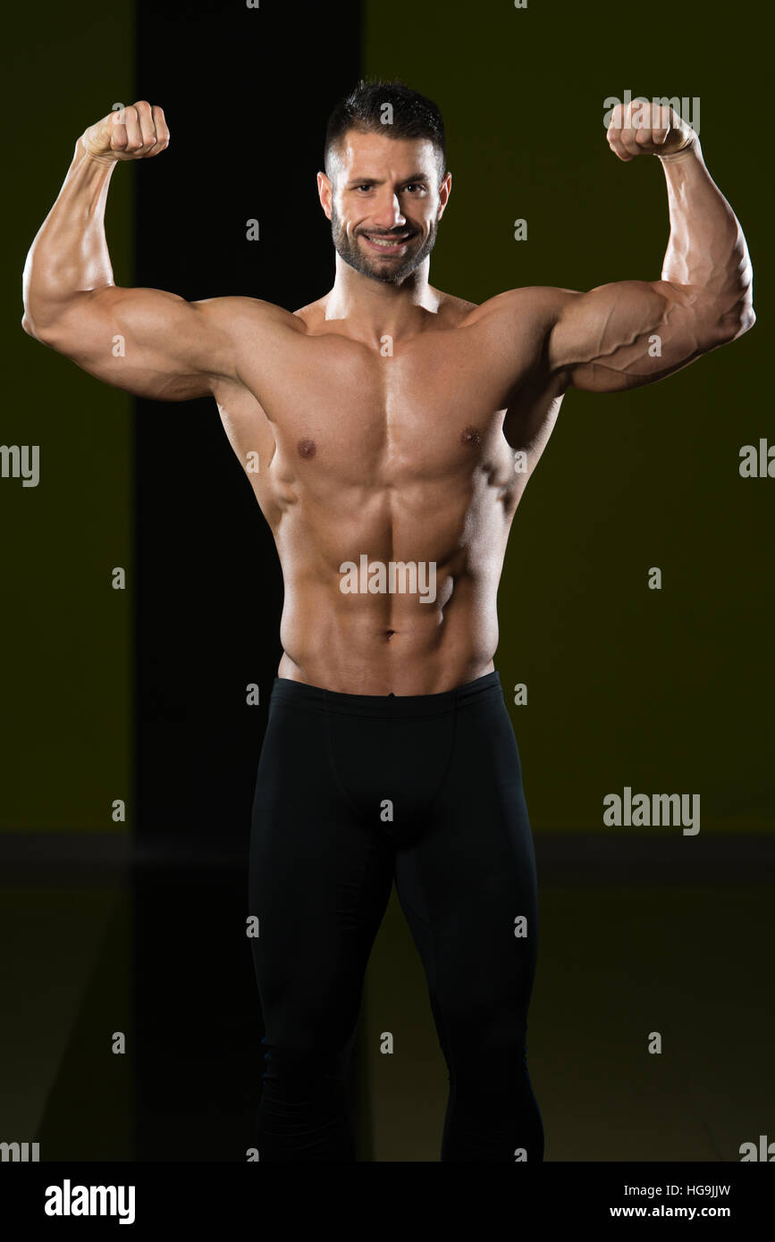 Healthy Man Standing Strong In The Gym And Flexing Muscles - Muscular ...