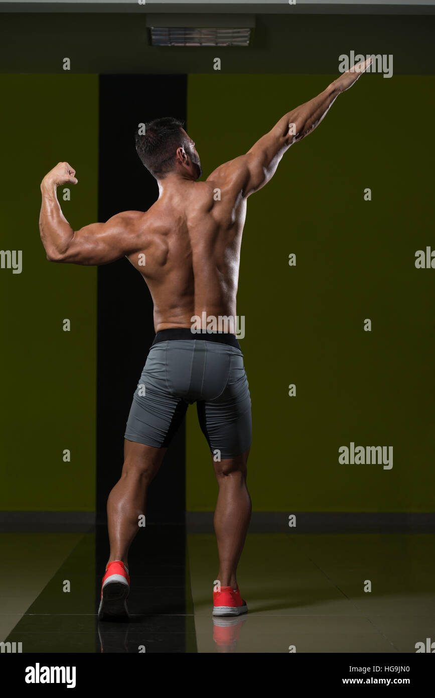 Healthy Man Standing Strong In The Gym And Flexing Muscles - Muscular ...