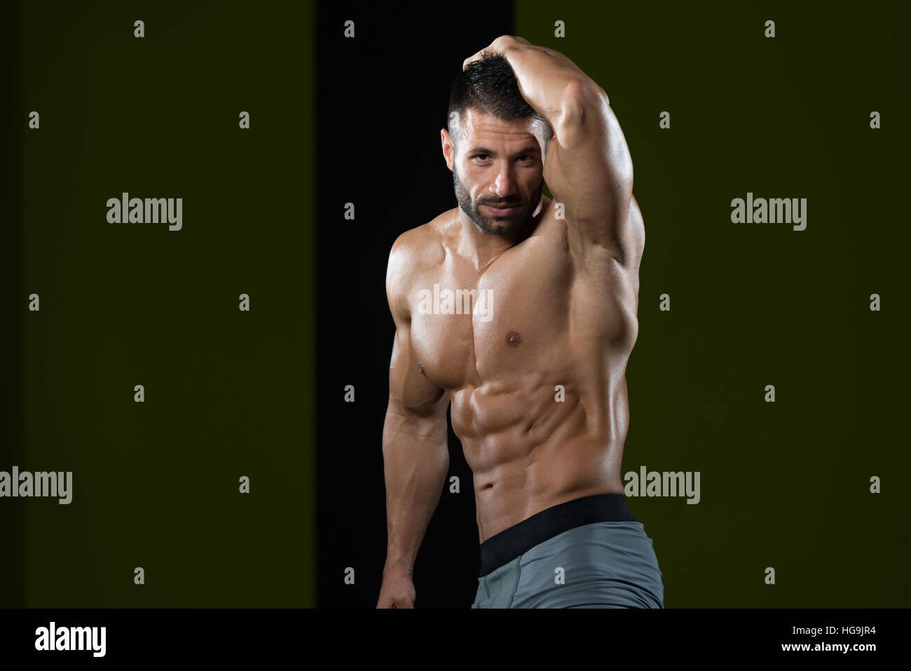 Handsome Man Standing Strong In The Gym And Flexing Muscles - Muscular ...