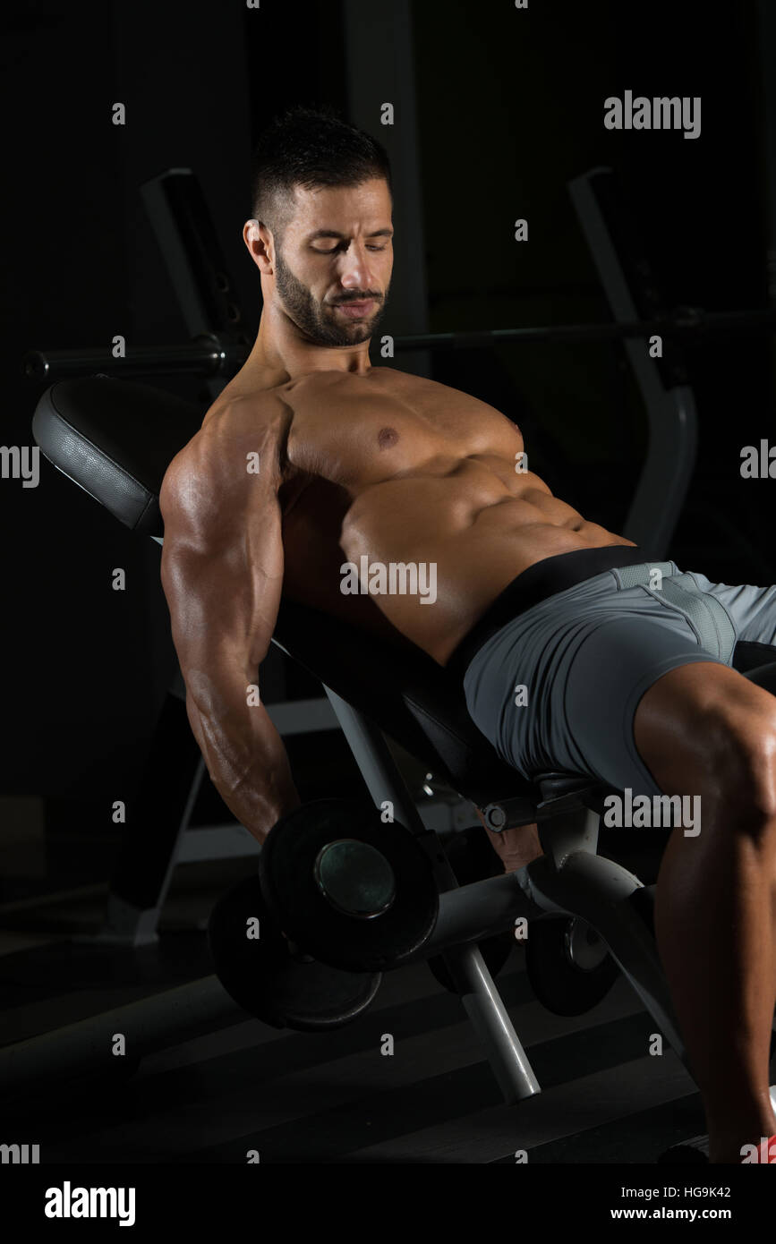 Healthy Man Working Out Biceps In A Dark Gym - Dumbbell Concentration ...