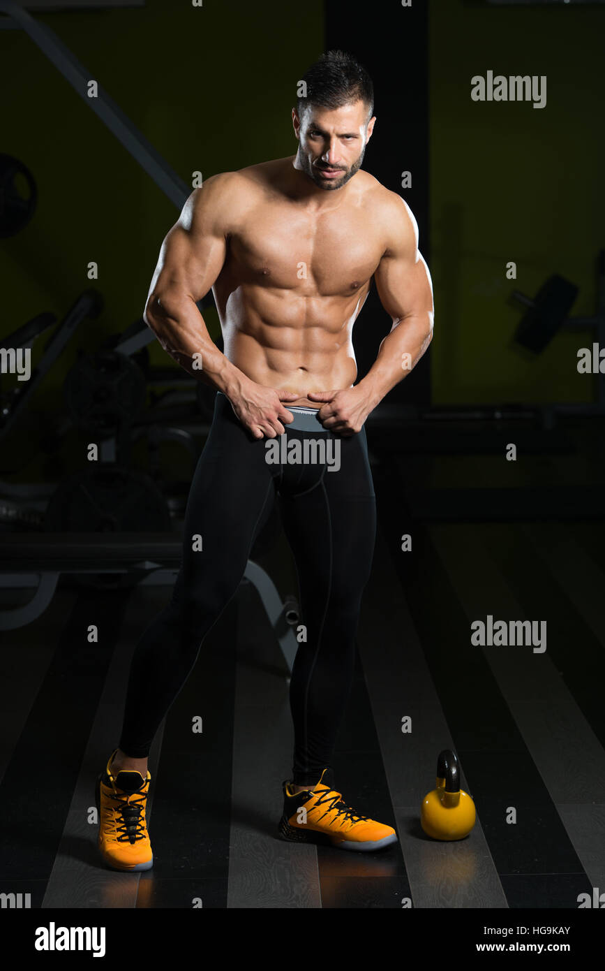 Healthy Man Standing Strong In The Gym And Flexing Muscles - Muscular ...