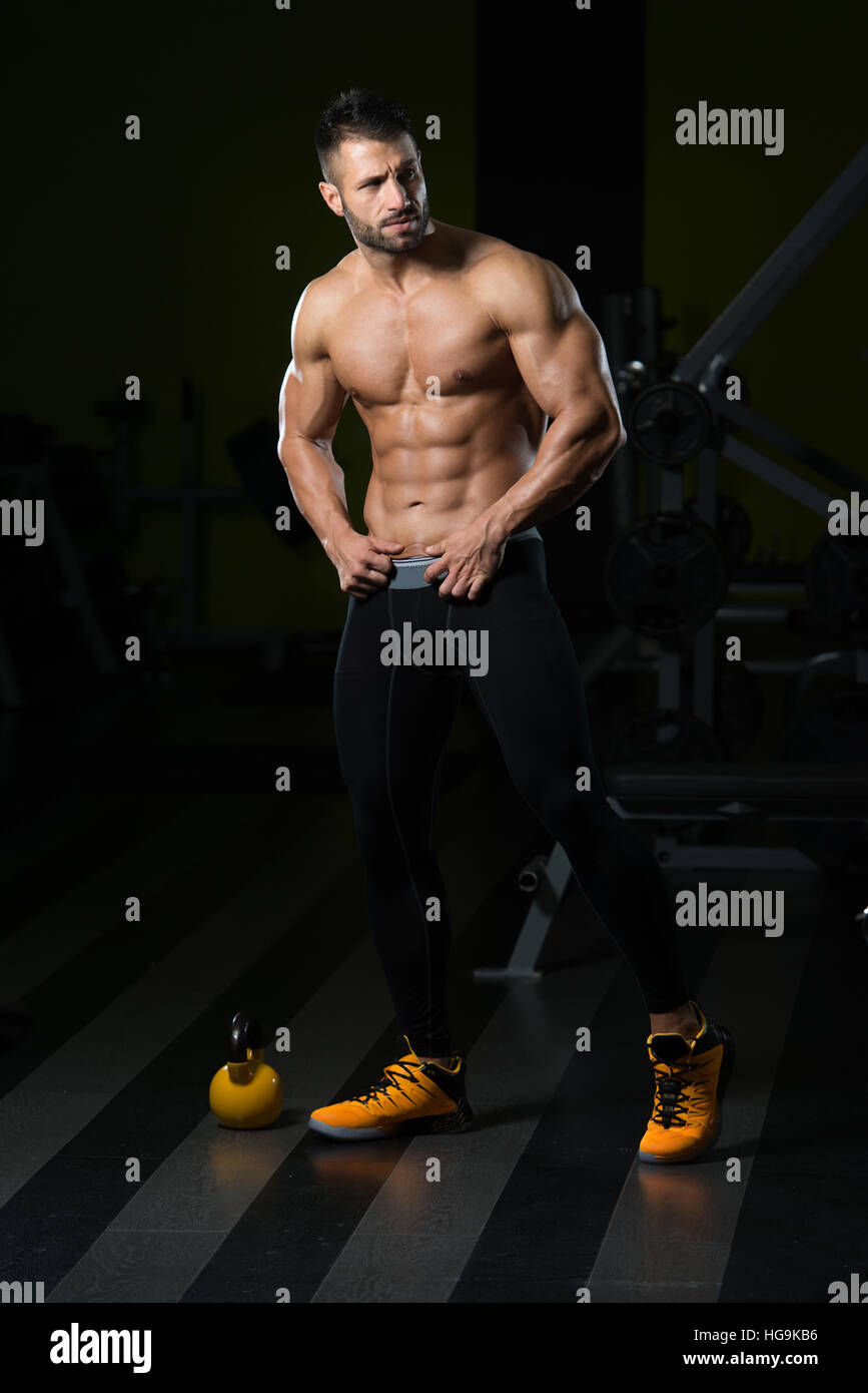 Healthy Man Standing Strong In The Gym And Flexing Muscles - Muscular ...