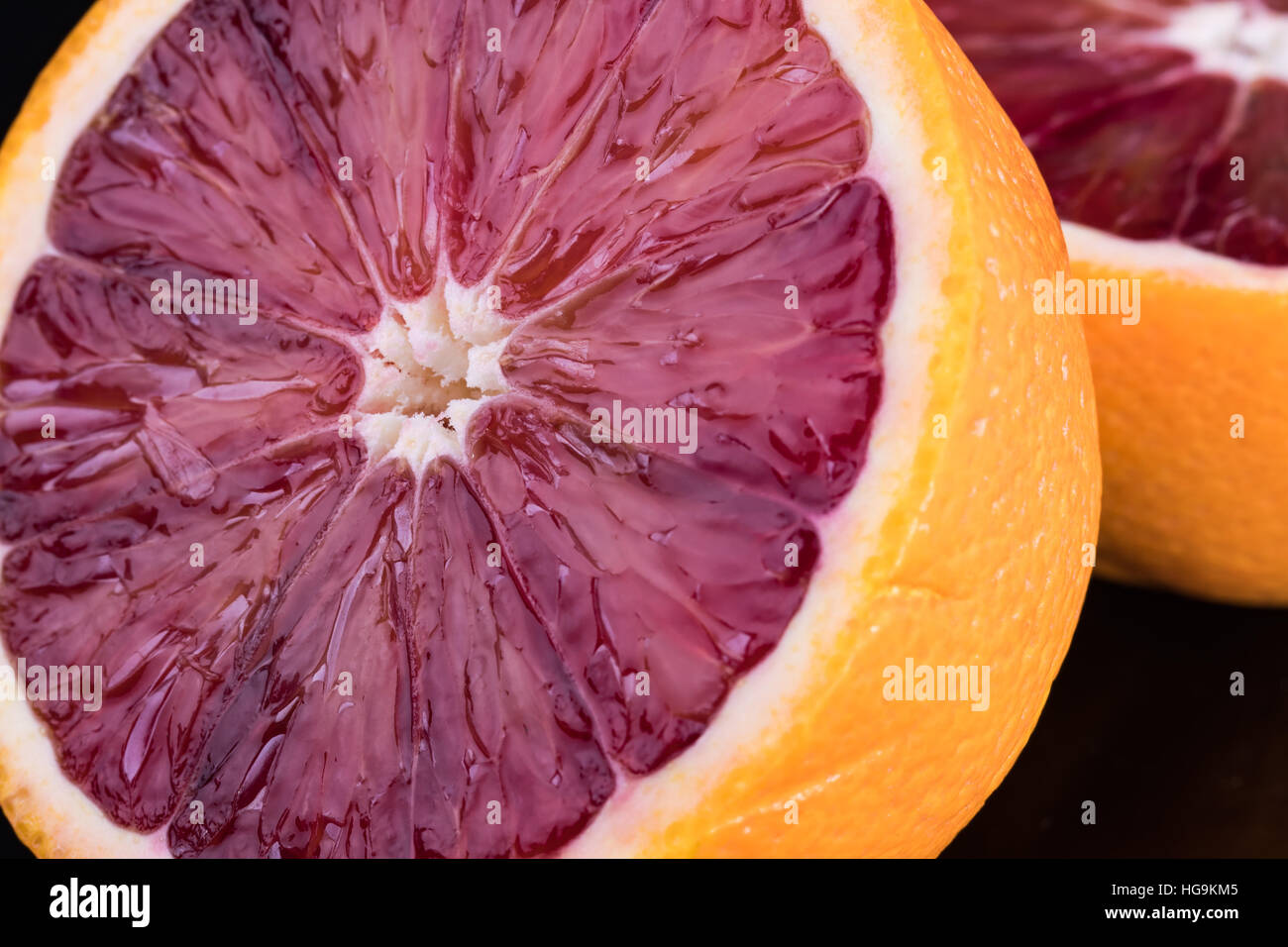 Cut blood orange on a black background Stock Photo - Alamy