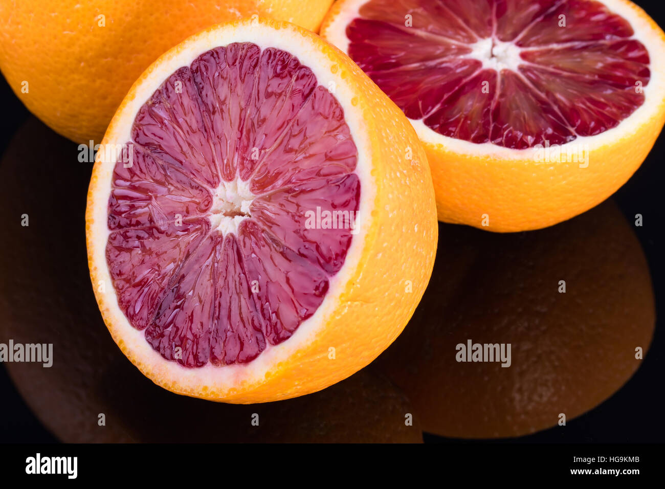 Cut blood orange on a black background Stock Photo - Alamy