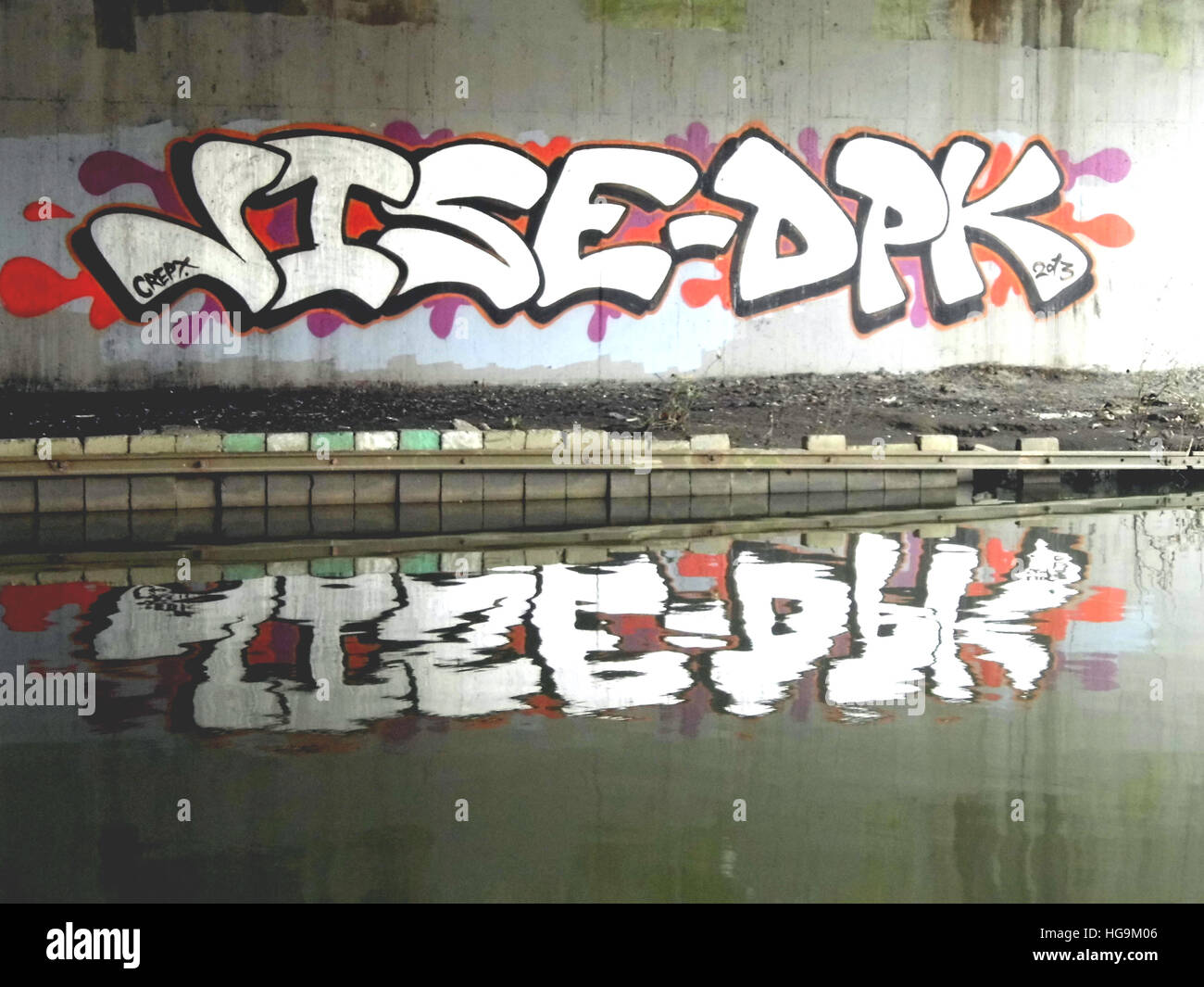 Graffiti drawn under a bridge on the Grand Union canal reflected on the ...