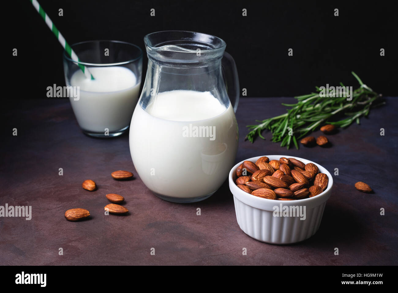 Homemade almond milk on dark rusty background over black background ...