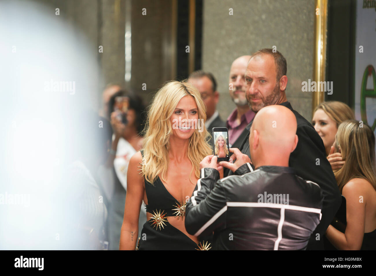 Howie Mandel takes a picture with a cell phone of Heidi Klum as they ...