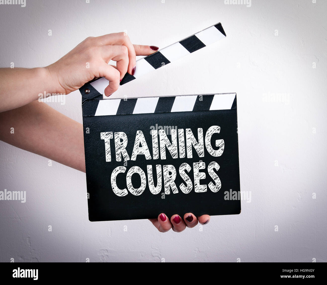 Training Courses. Female hands holding movie clapper Stock Photo - Alamy