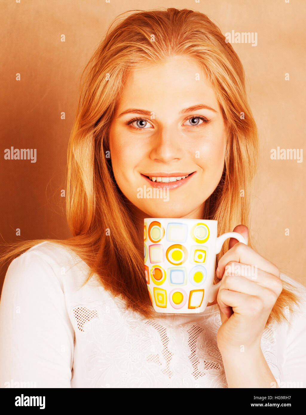 young cute blond girl drinking coffee close up on warm brown bac Stock ...