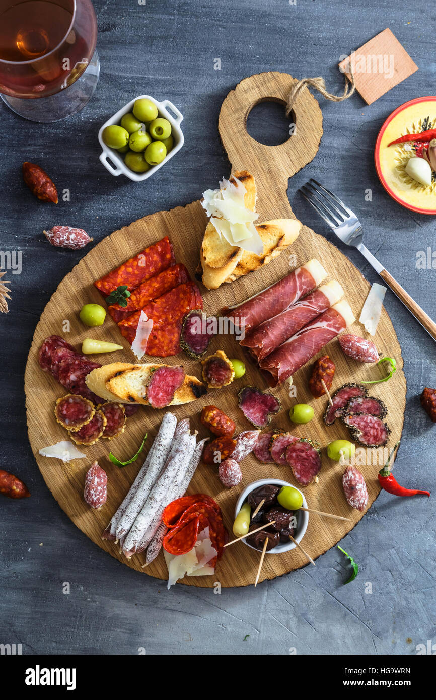 Different spanish embutidos on a table: jamon, chorizo, salami, cheese ...