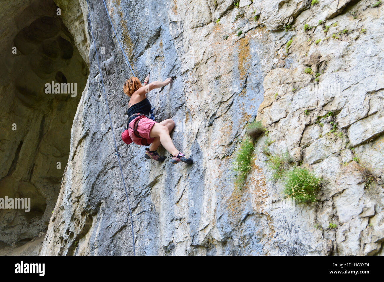 Young woman rock climber high on a vertical wall in Prohodna Cave Stock ...