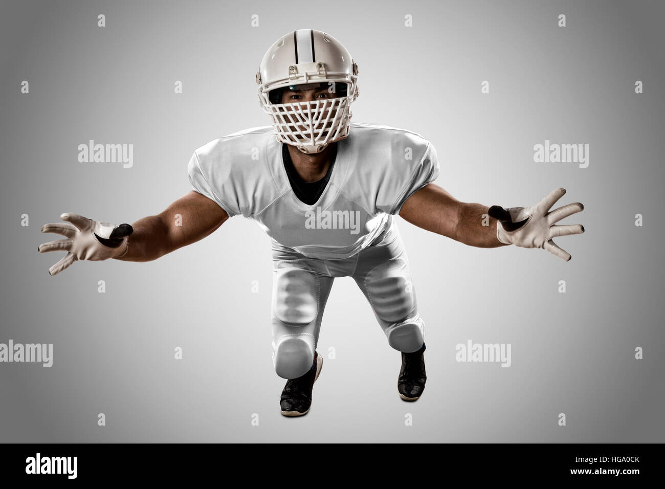 Football Player with a white uniform making a tackle on a white ...