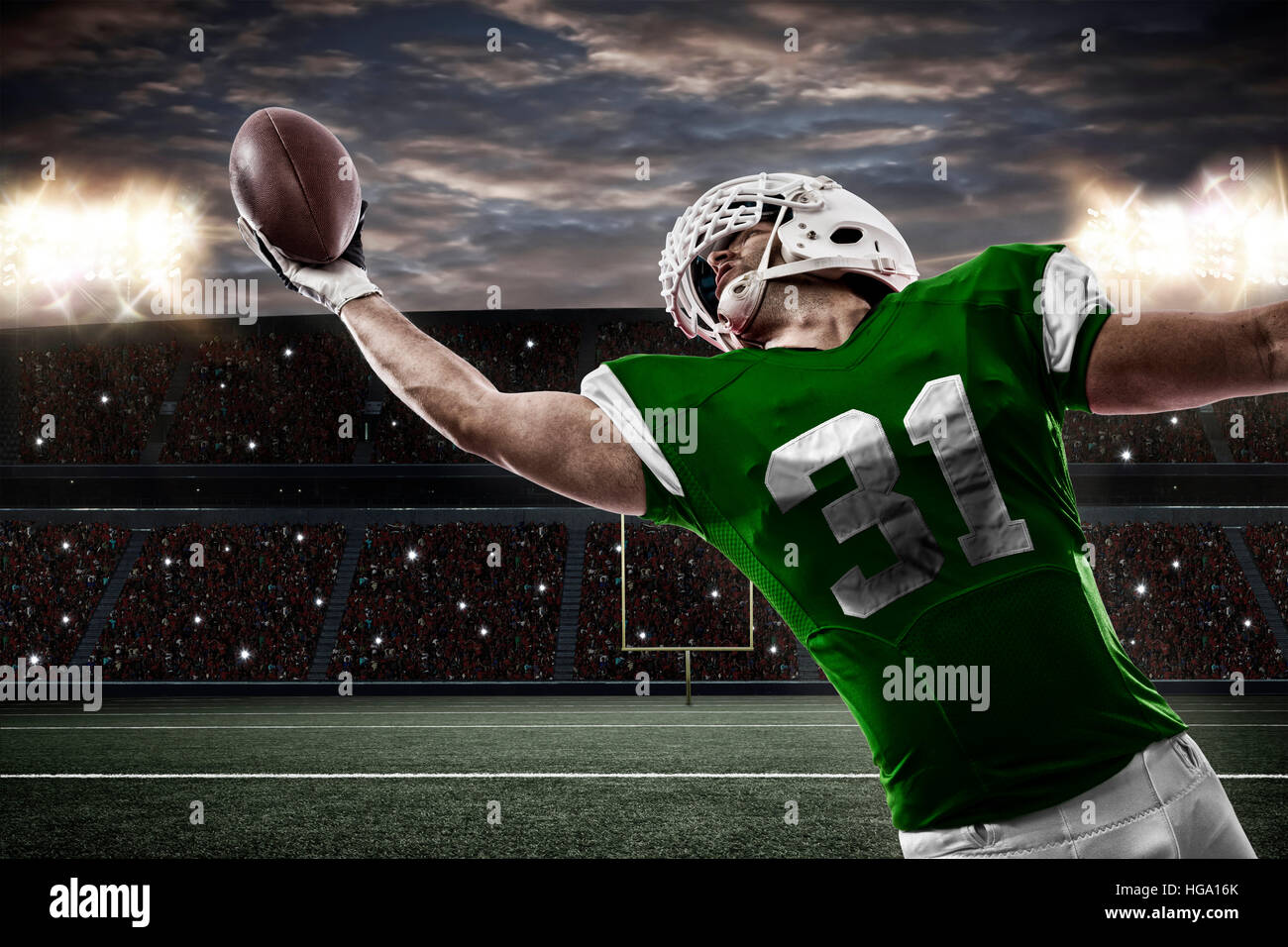 Football Player with a green uniform catching a ball on a stadium Stock ...