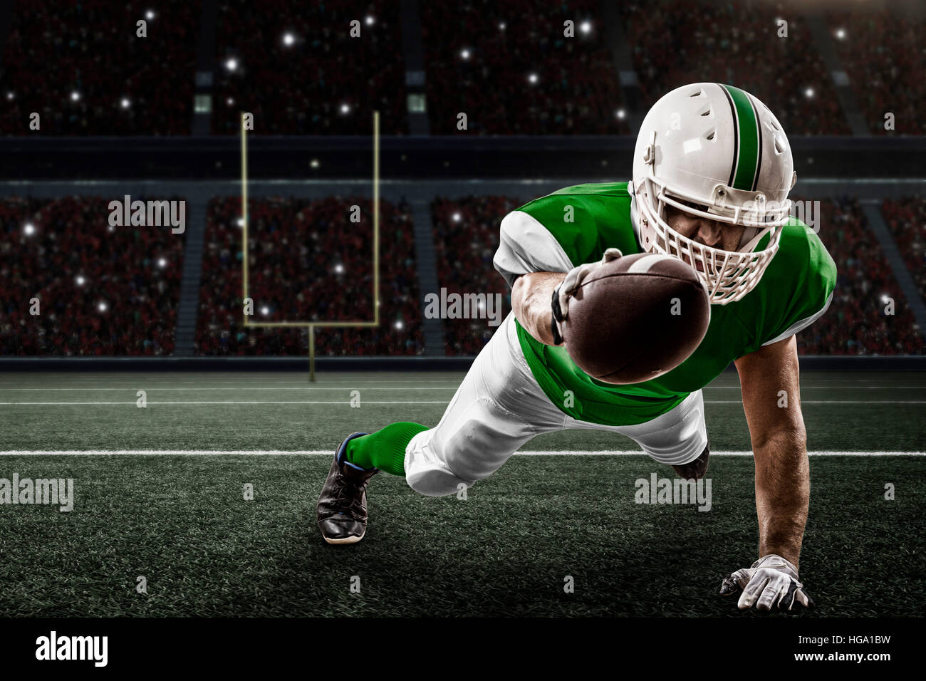Football Player with a green uniform scoring on a Stadium Stock Photo ...