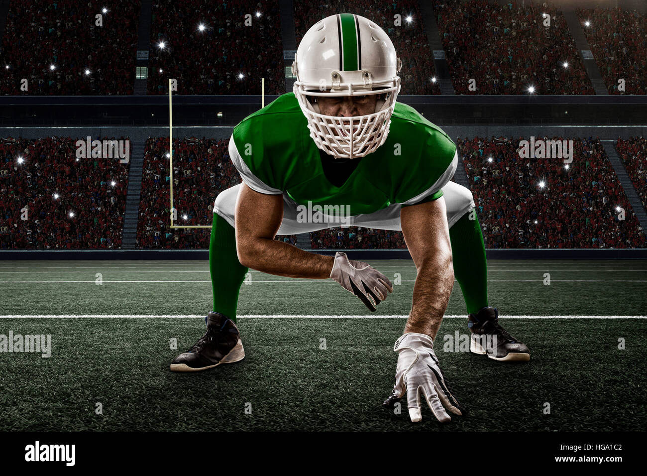Football Player with a green uniform on the scrimmage line, on a ...