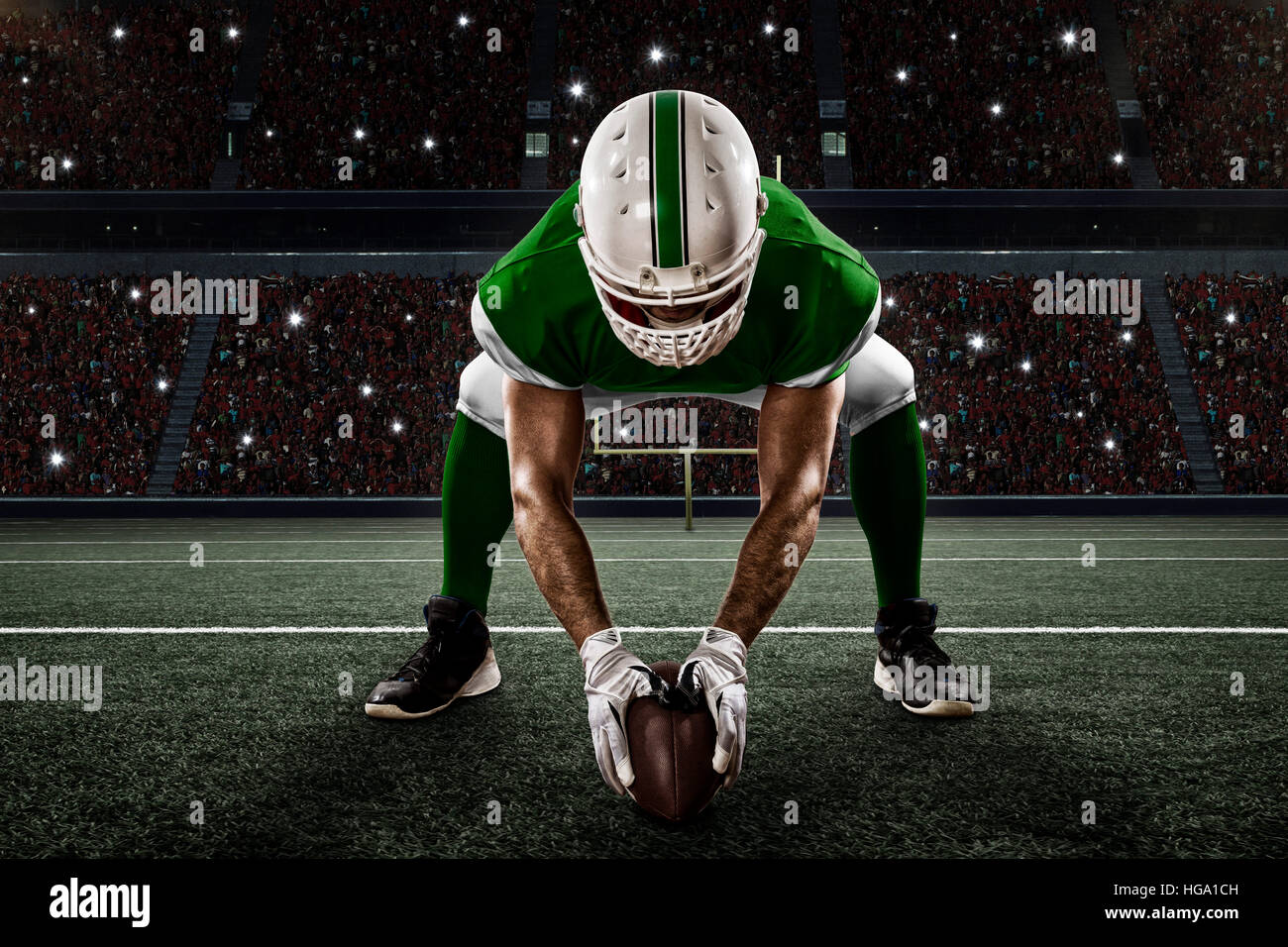 Football Player with a green uniform on the scrimmage line, on a ...