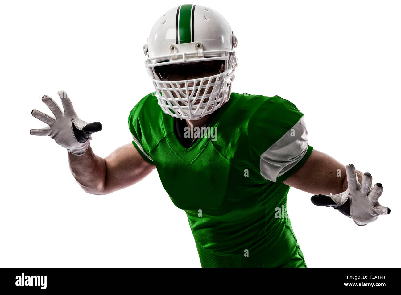 Football Player with a Green uniform making a tackle on a white ...