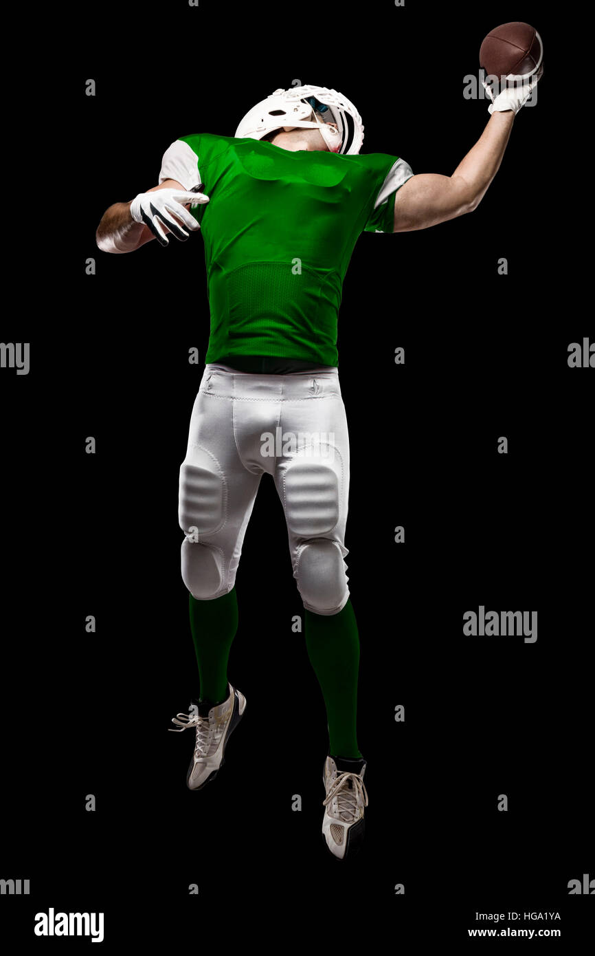 Football Player with a Green uniform making a catching on a black ...