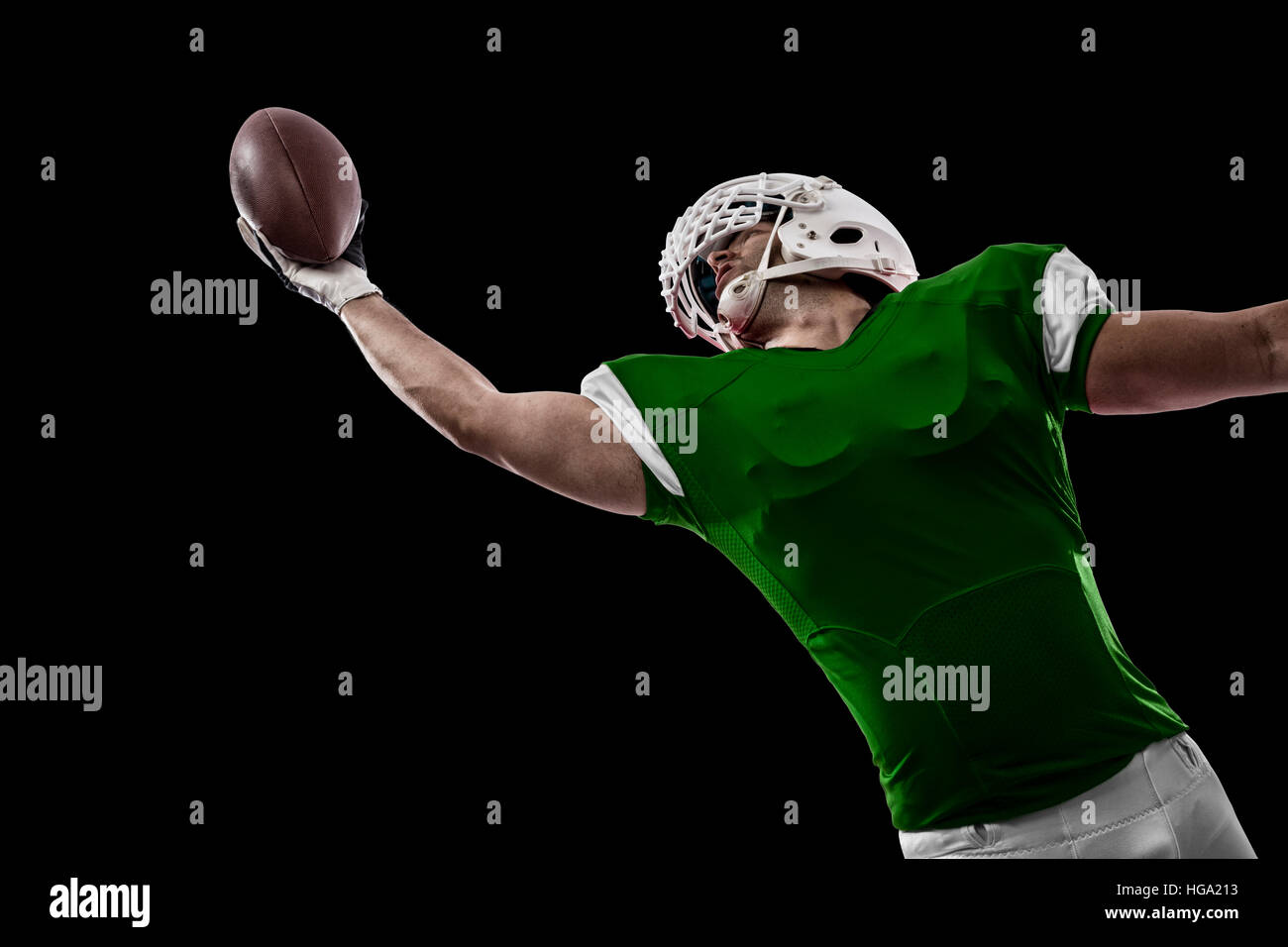 Football Player with a Green uniform making a catching on a black ...
