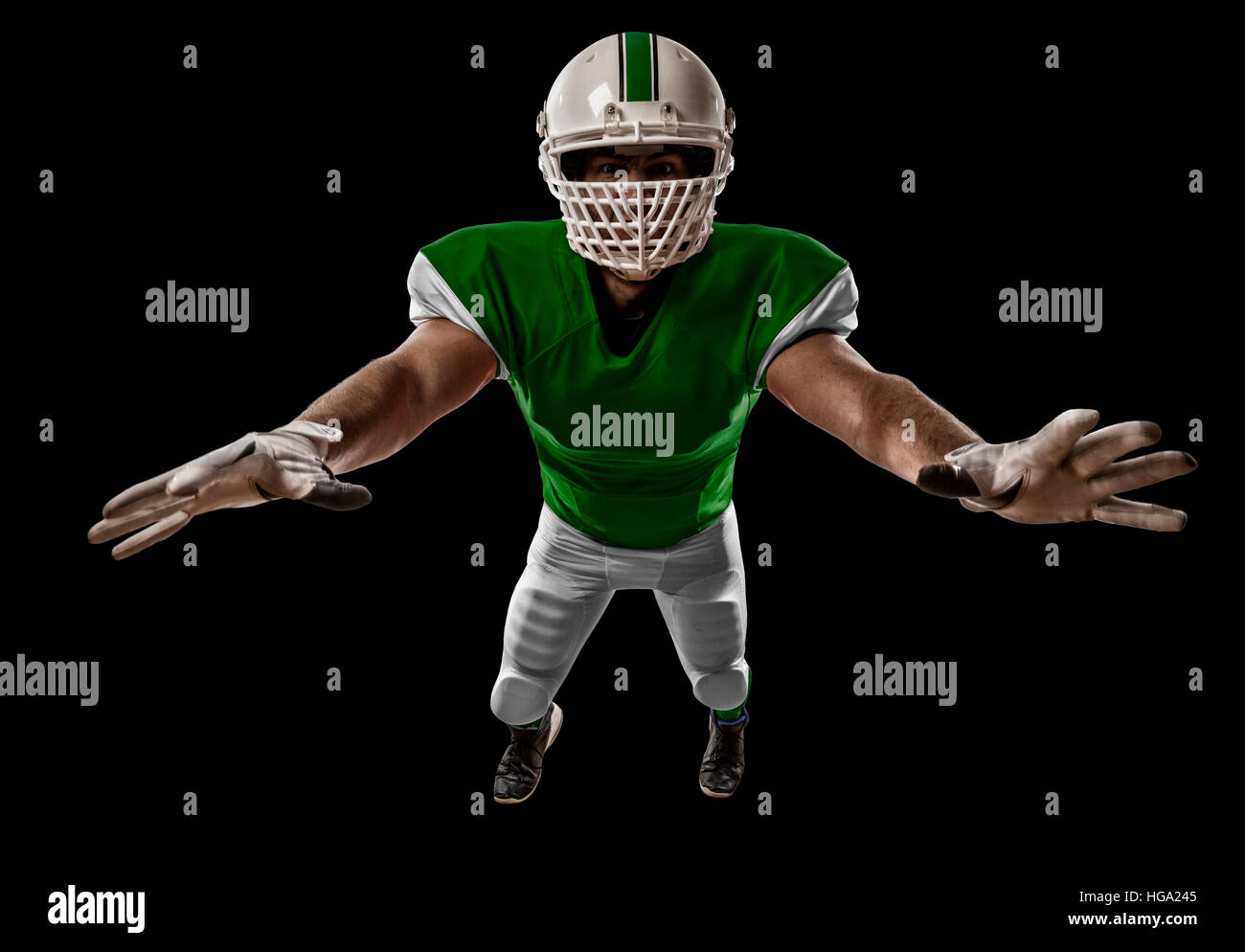 Football Player with a Green uniform making a tackle on a black ...