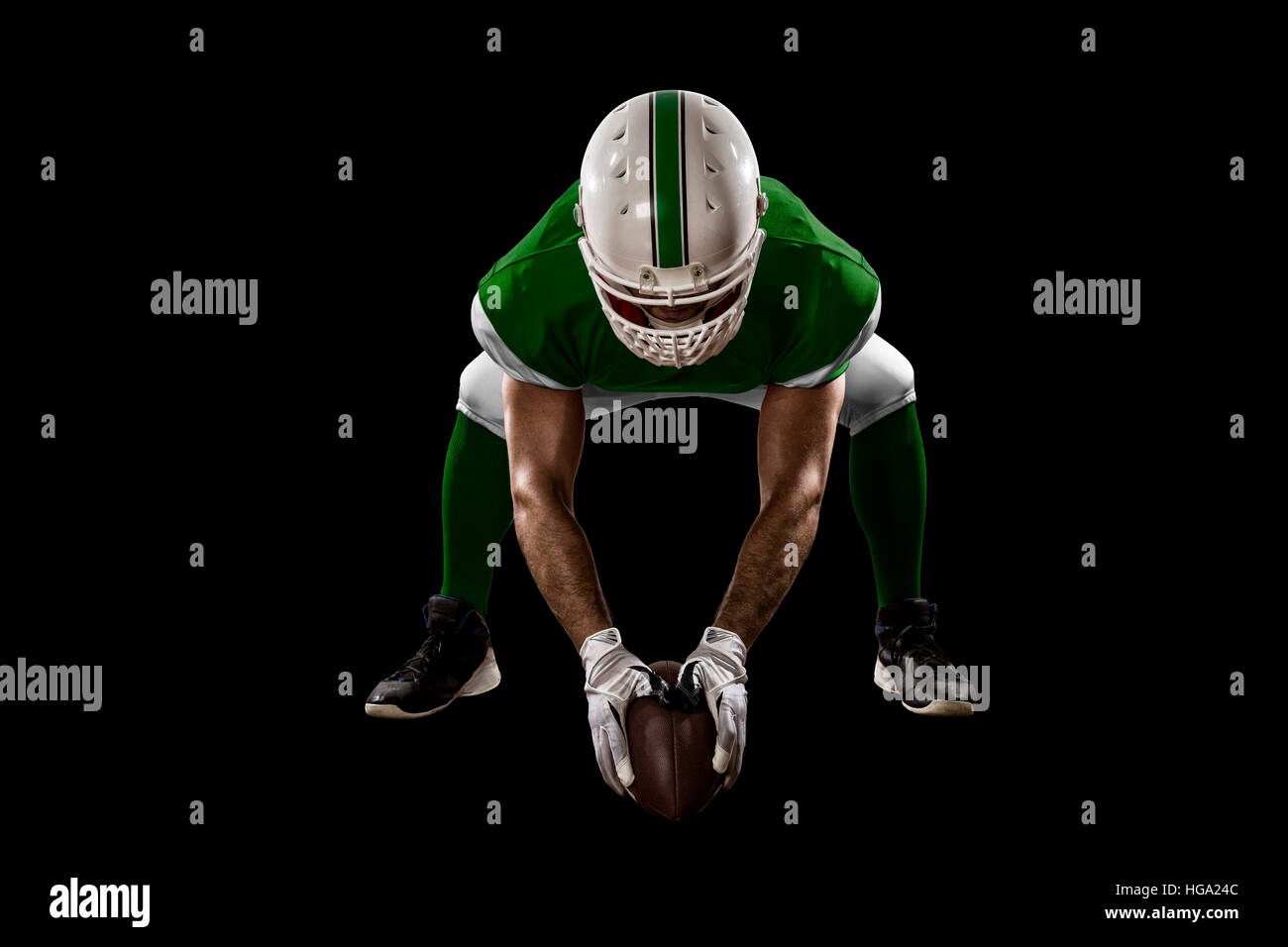 Football Player with a Green uniform on the scrimmage line, on a black ...