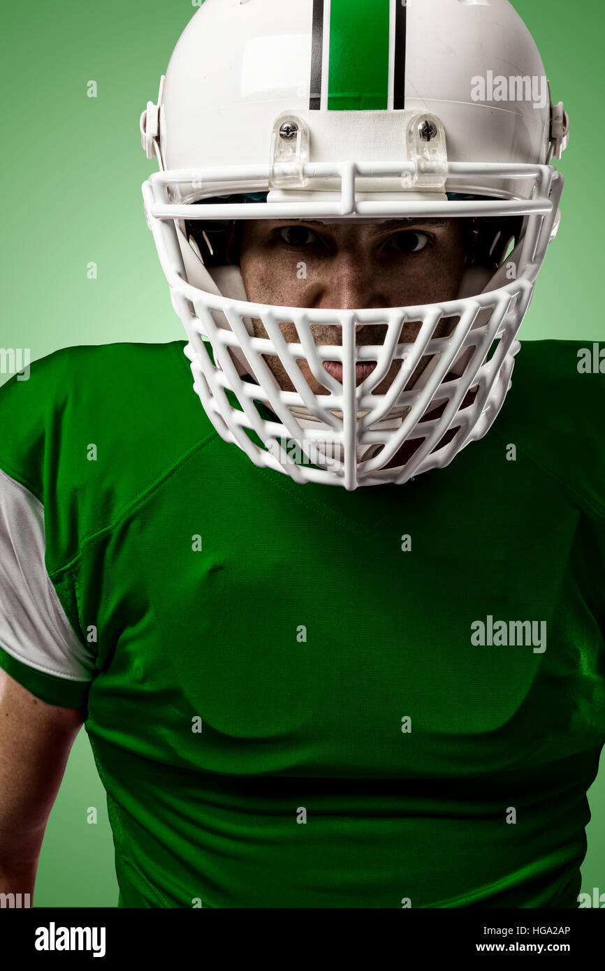 Close up of a Football Player with a green uniform on a green ...