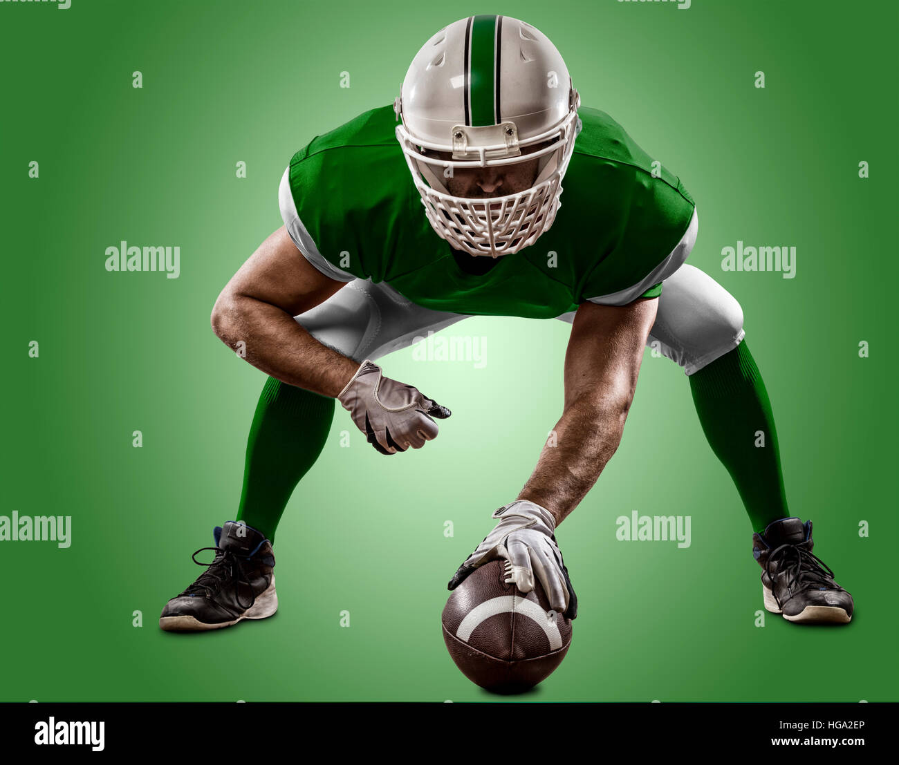 Football Player with a green uniform on the scrimmage line, on a green ...