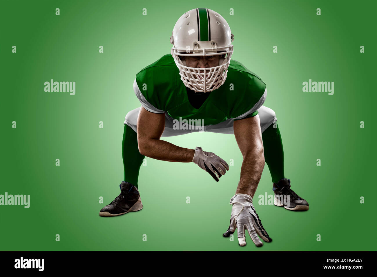 Football Player with a green uniform on the scrimmage line, on a green ...