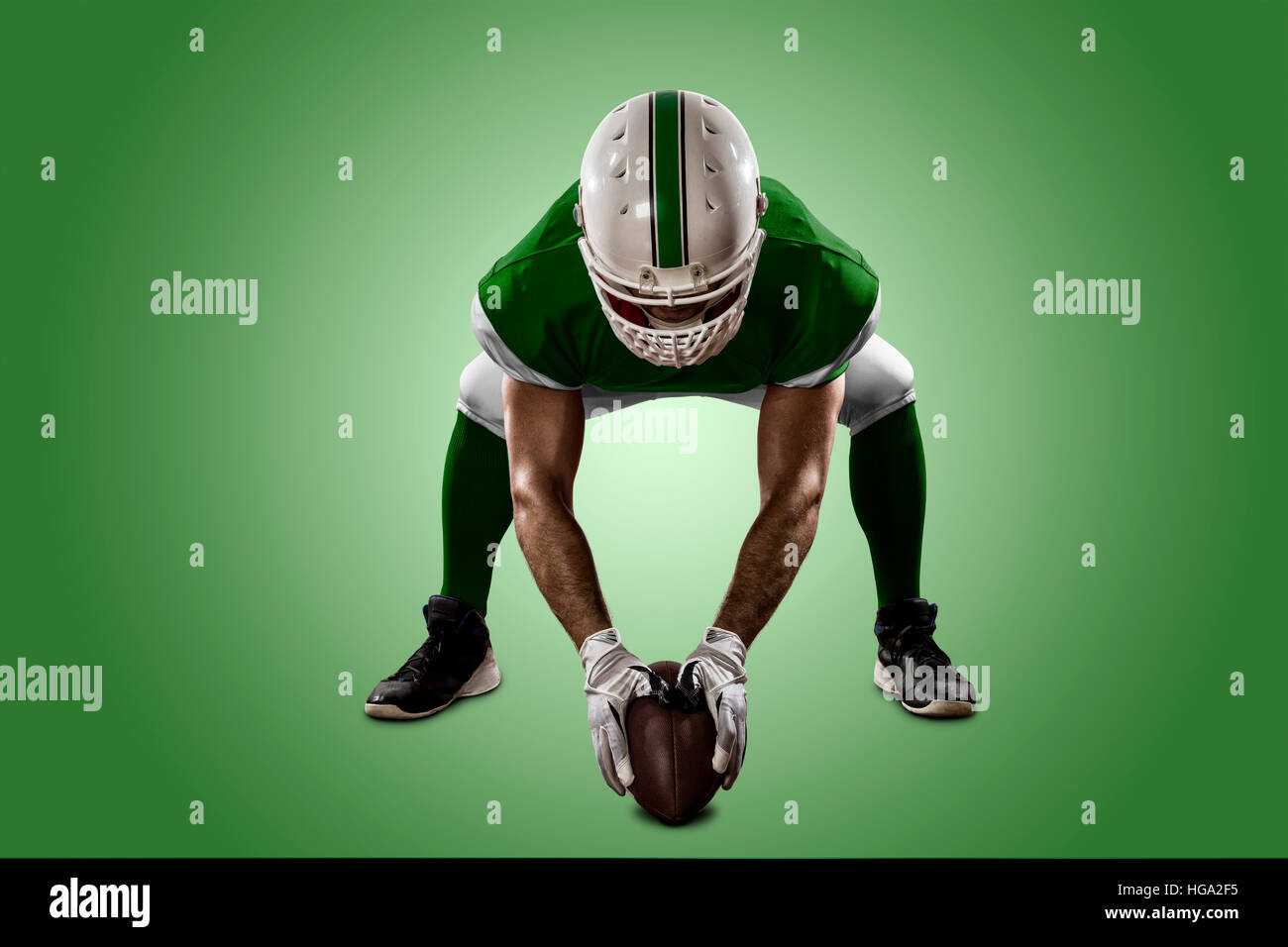 Football Player with a green uniform on the scrimmage line, on a green ...