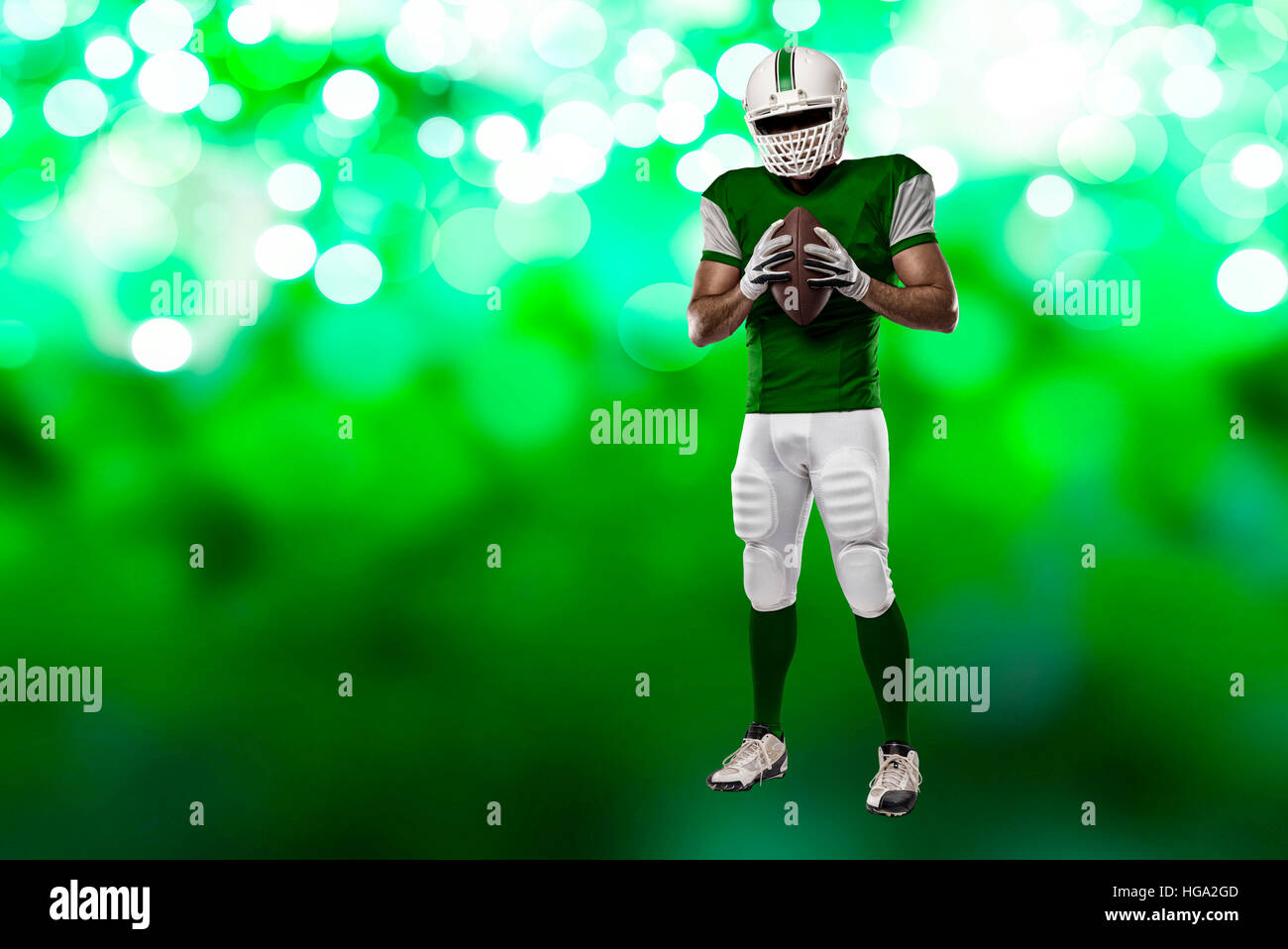 Football Player with a green uniform on a green lights background Stock ...