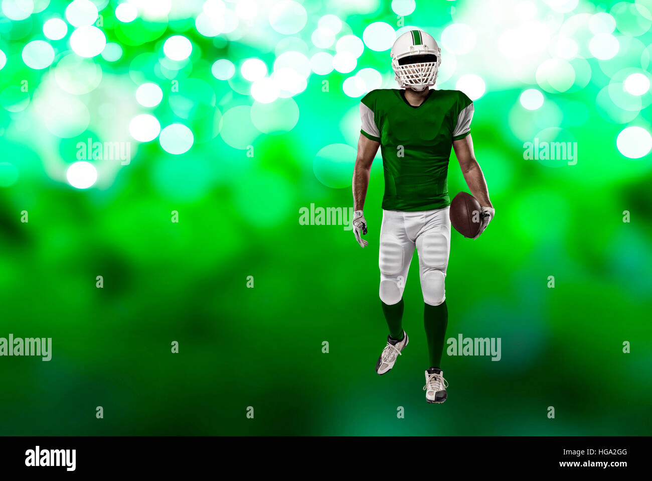 Football Player with a green uniform on a green lights background Stock ...