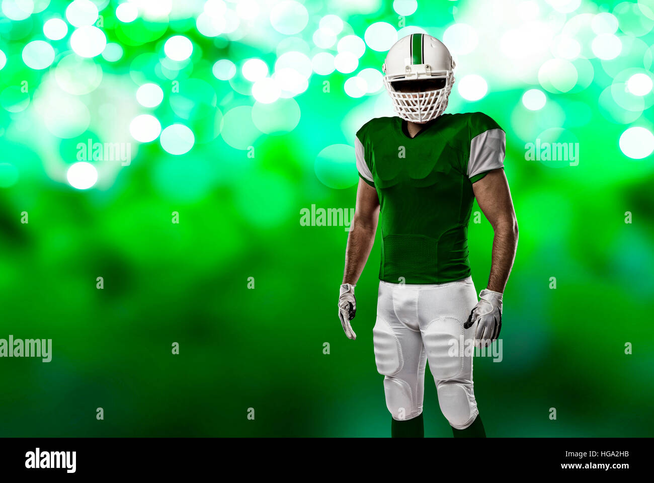 Football Player with a green uniform on a green lights background Stock ...