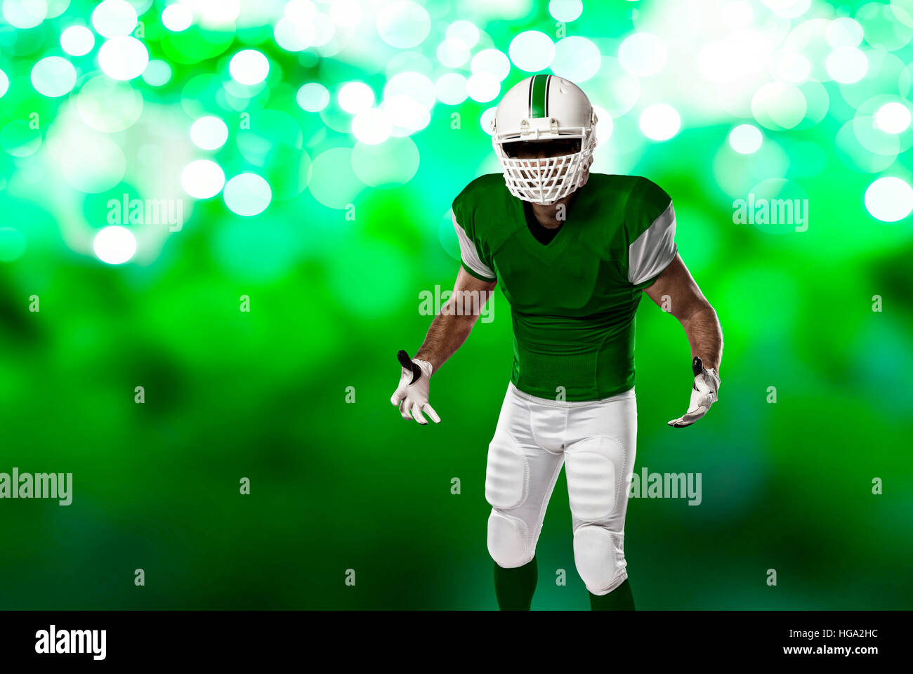 Football Player with a green uniform on a green lights background Stock ...