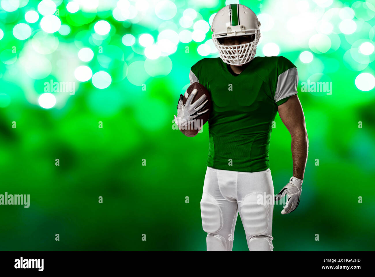 Football Player with a green uniform on a green lights background Stock ...
