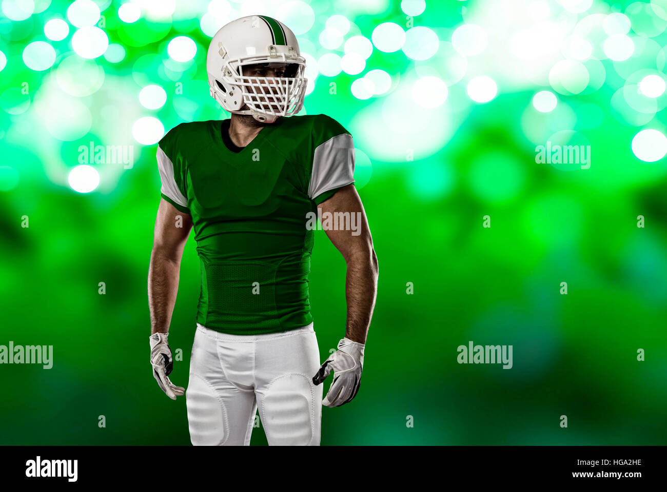 Football Player with a green uniform on a green lights background Stock ...