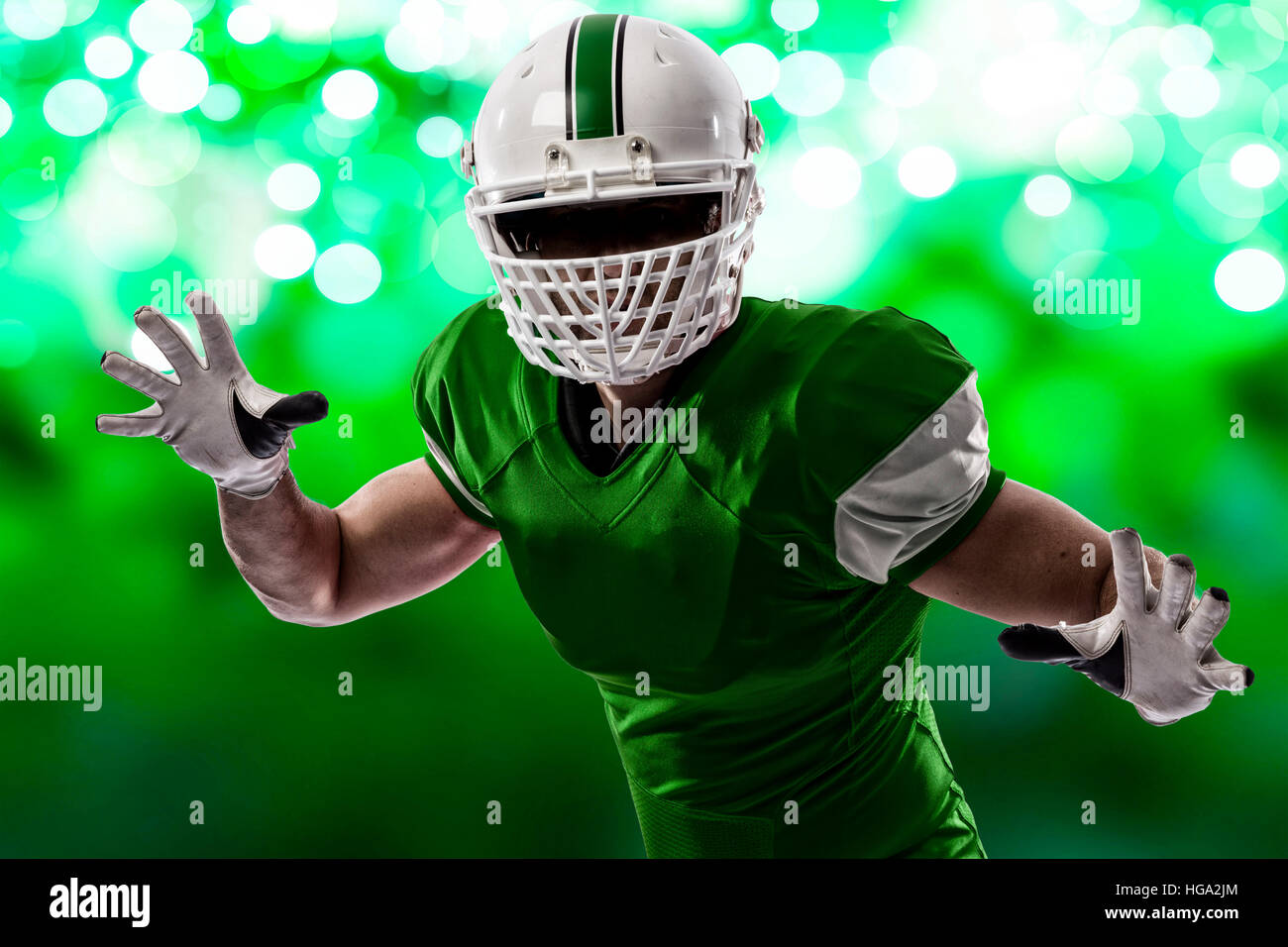 Football Player with a green uniform making a tackle on a green lights ...