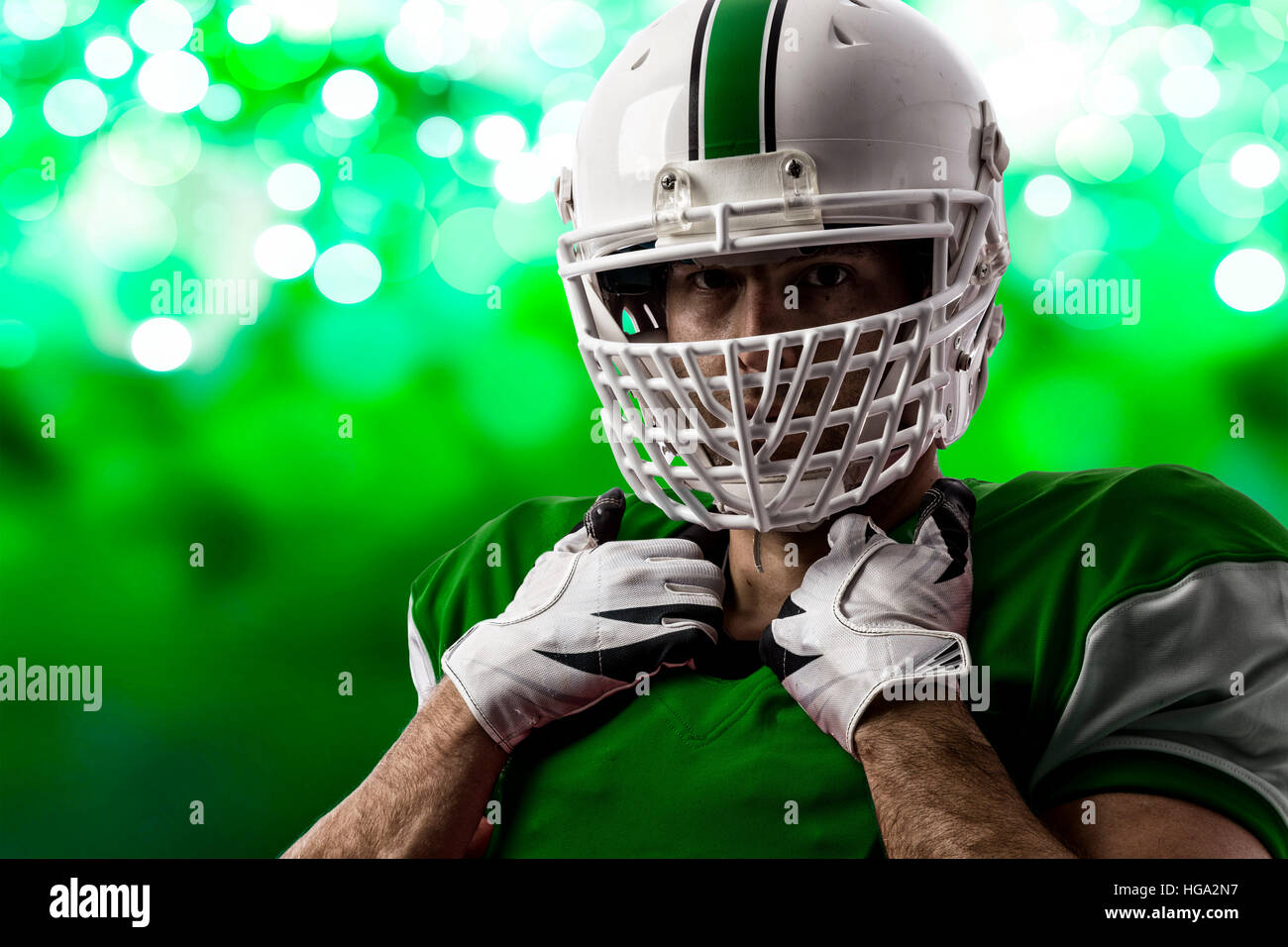 Football Player with a green uniform on a green lights background Stock ...