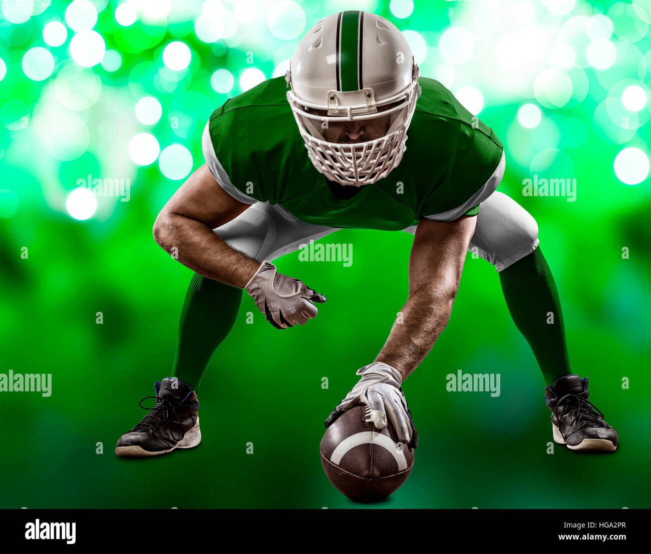 Football Player with a green uniform on the scrimmage line, on a green ...