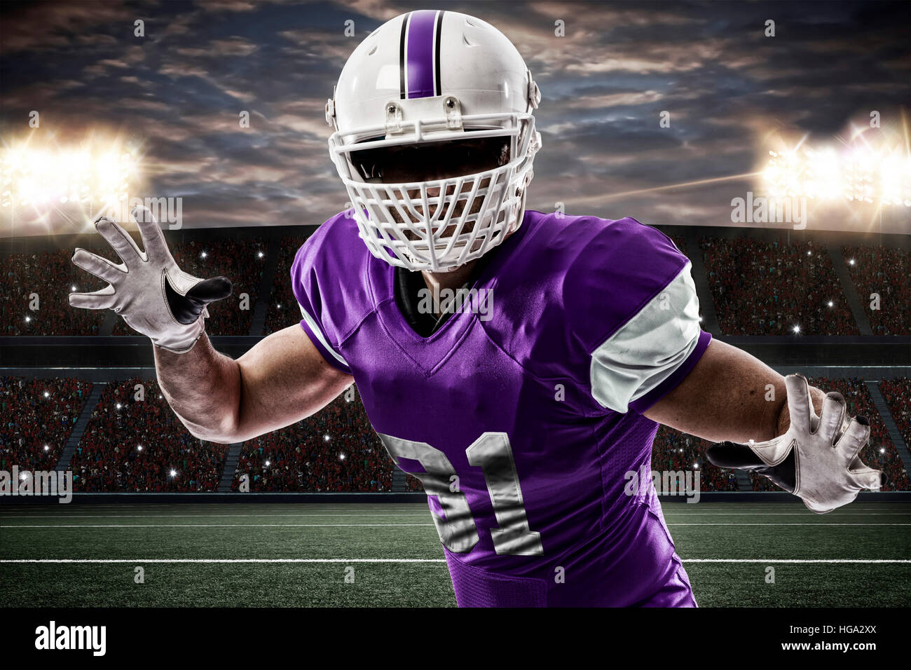 Football Player with a purple uniform making a tackle on a stadium ...