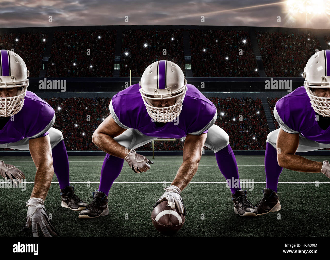 Football Players with a purple uniform on the scrimmage line, on a ...