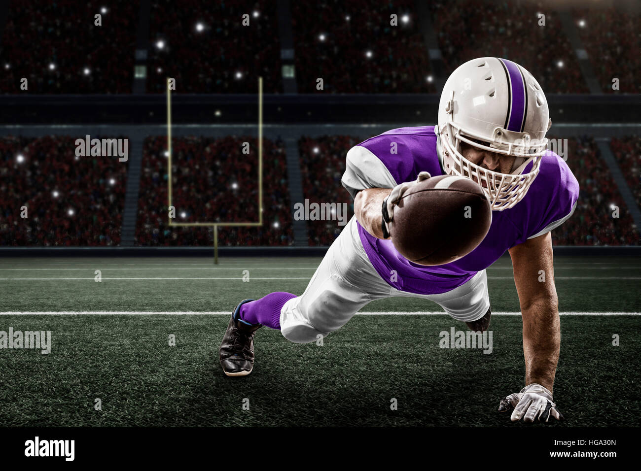 Football Player with a purple uniform scoring on a Stadium Stock Photo ...