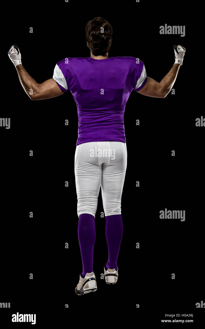 Football Player with a purple uniform walking, showing his back on a ...