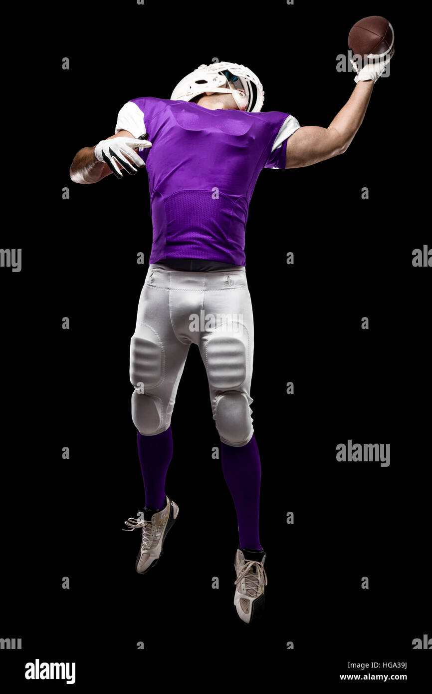 Football Player with a purple uniform making a catching on a black ...