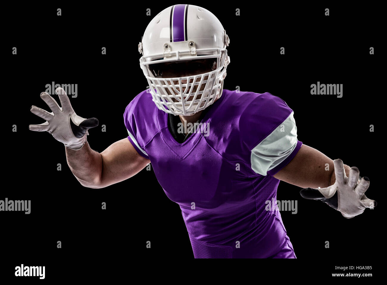 Football Player with a purple uniform making a tackle on a black ...