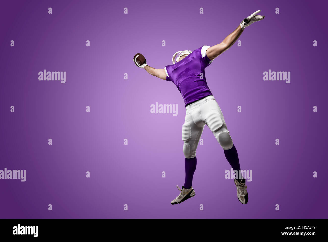 Football Player with a purple uniform making a catch on a purple ...