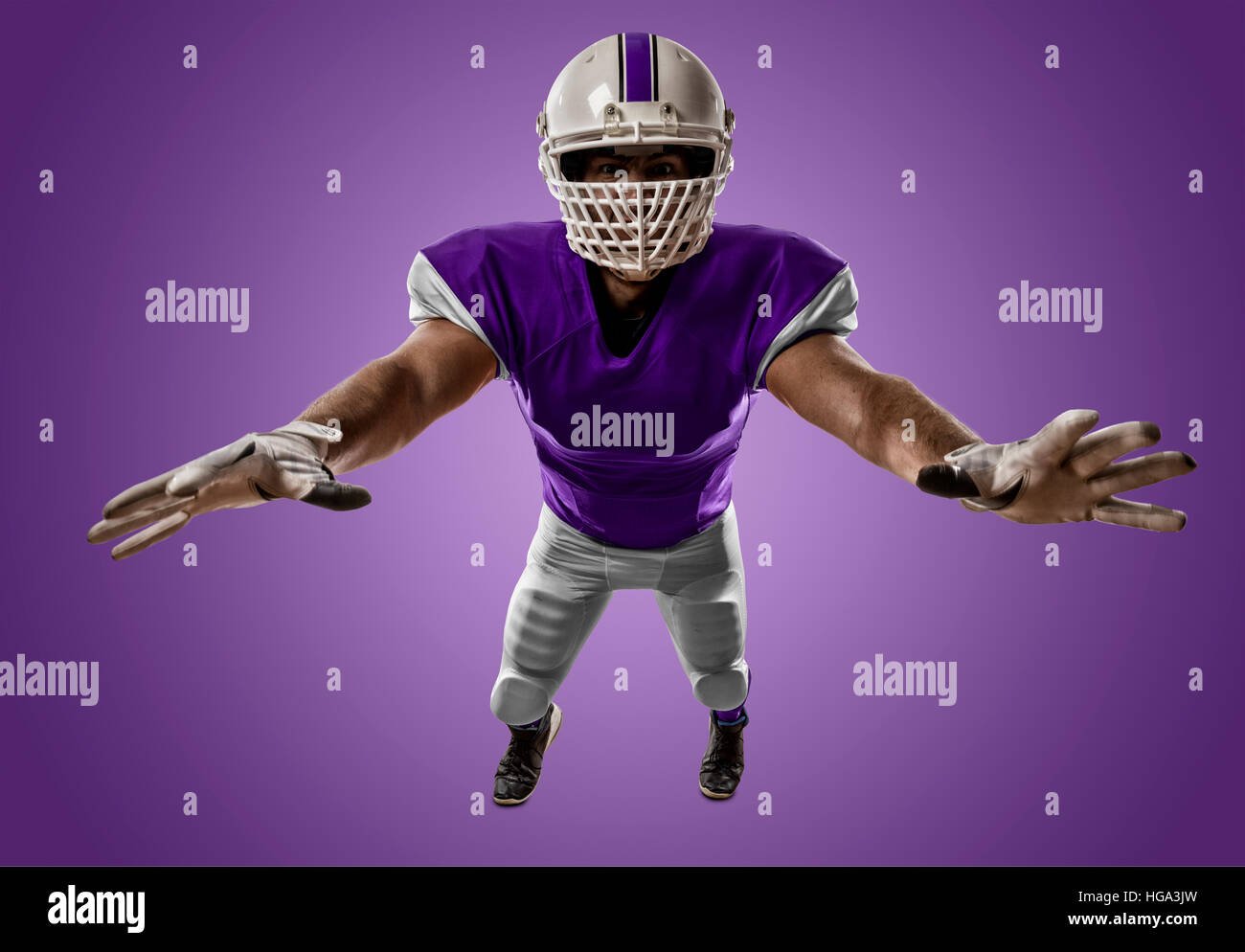 Football Player with a purple uniform making a tackle on a purple ...