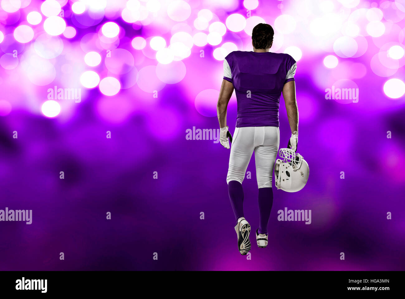Football Player with a purple uniform walking, showing his back on a ...