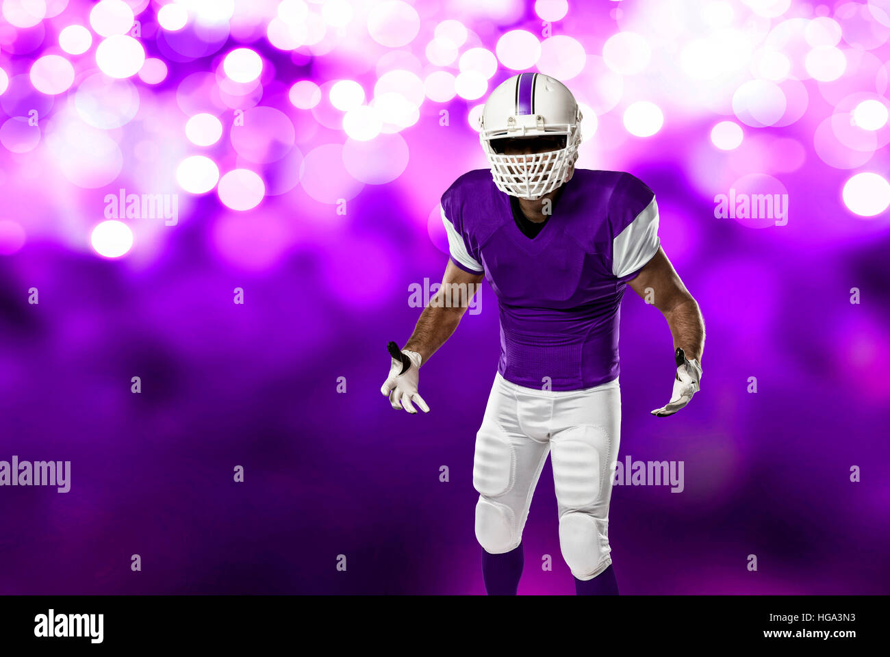 Football Player with a purple uniform on a purple lights background ...