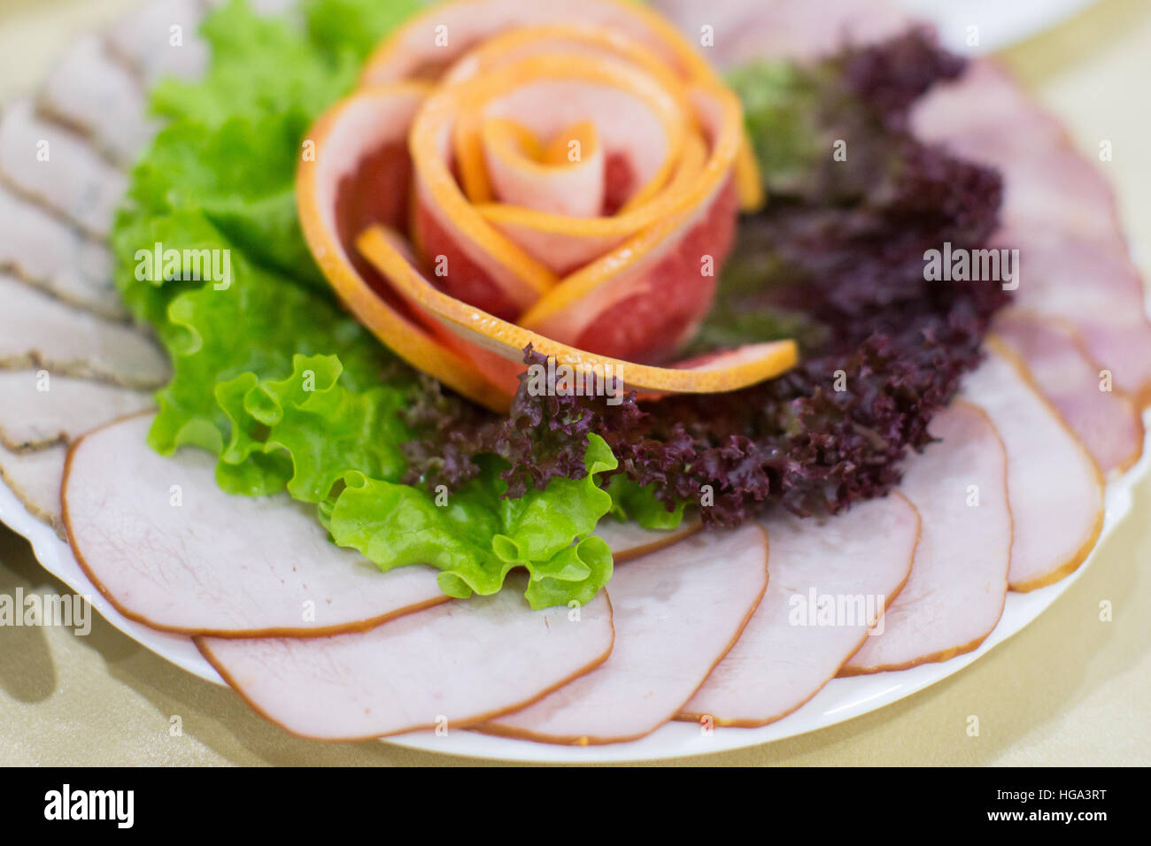 Dinning table set with baked sliced ham, garnished with salad Stock ...